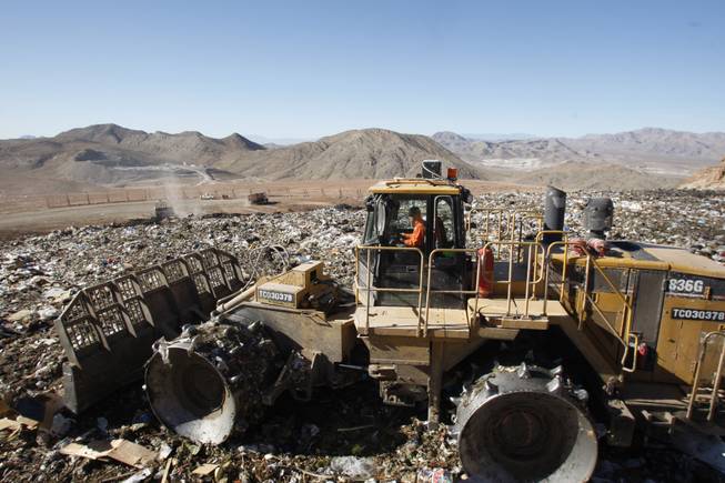 Southern Nevada landfill - An operator drivers a compacter over garbage ...