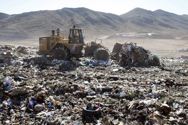 Southern Nevada landfill - An operator drivers a compacter over garbage ...