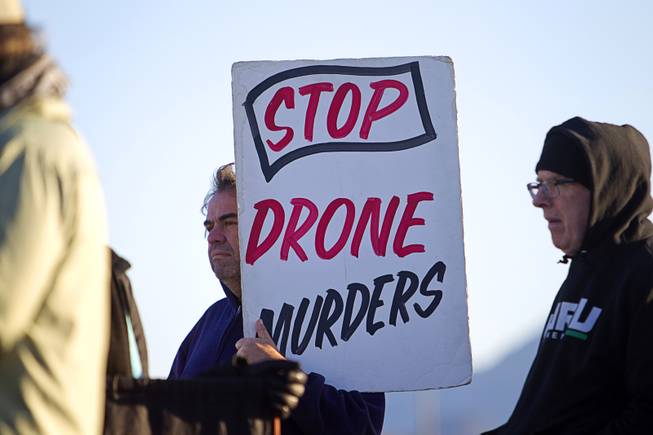 Anti-Drone Activists Arrested at Creech AFB - A protester hold a sign ...