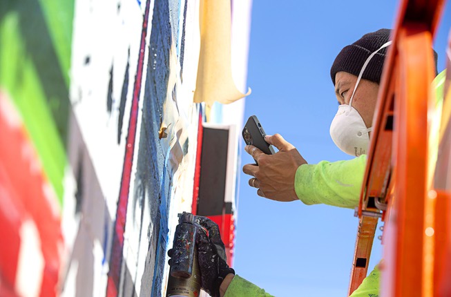 Greetings From Las Vegas Mural - Artist Victor Ving works on a ...